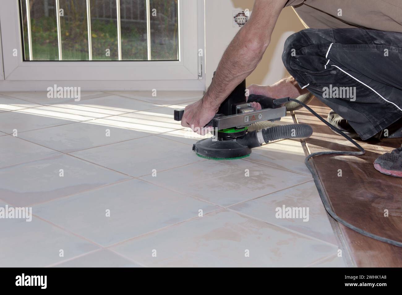 Man is working with a Grinder. Tiles floor surface grinding by electric ...