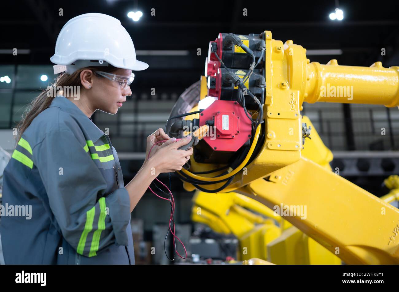 In the robots warehouse, A female engineer inspects the electrical ...