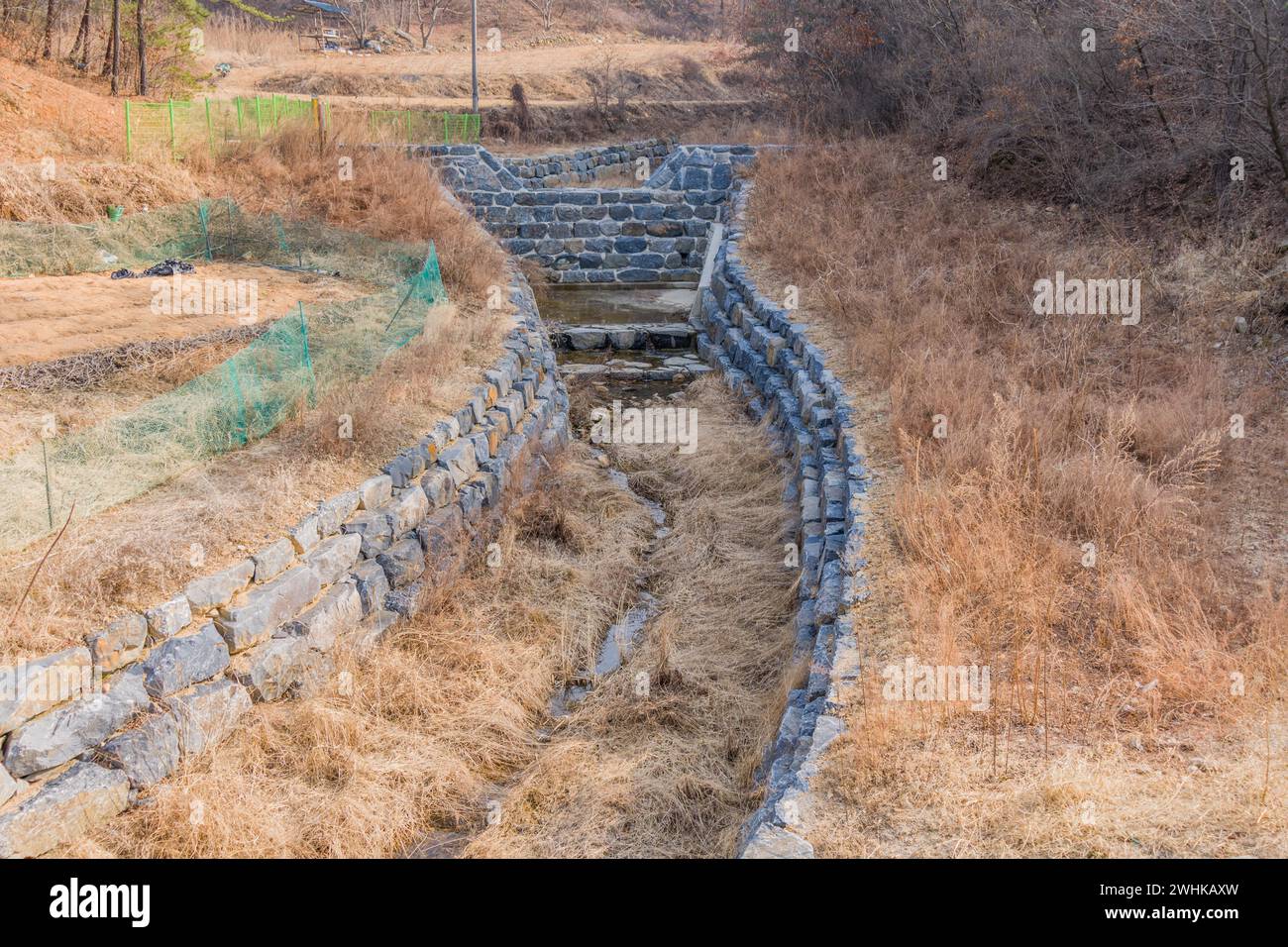 Landscape of drainage channel made of large boulders in a rural ...
