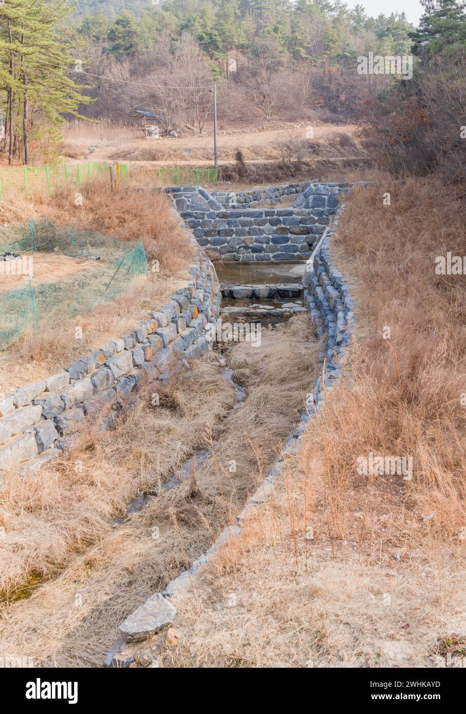 Landscape of drainage channel made of large boulders in a rural ...
