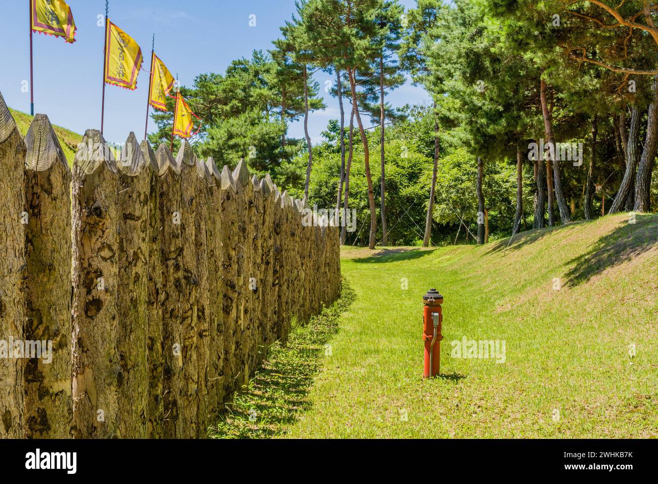 Water hydrant in front of fortress wall made of sharpened logs located ...