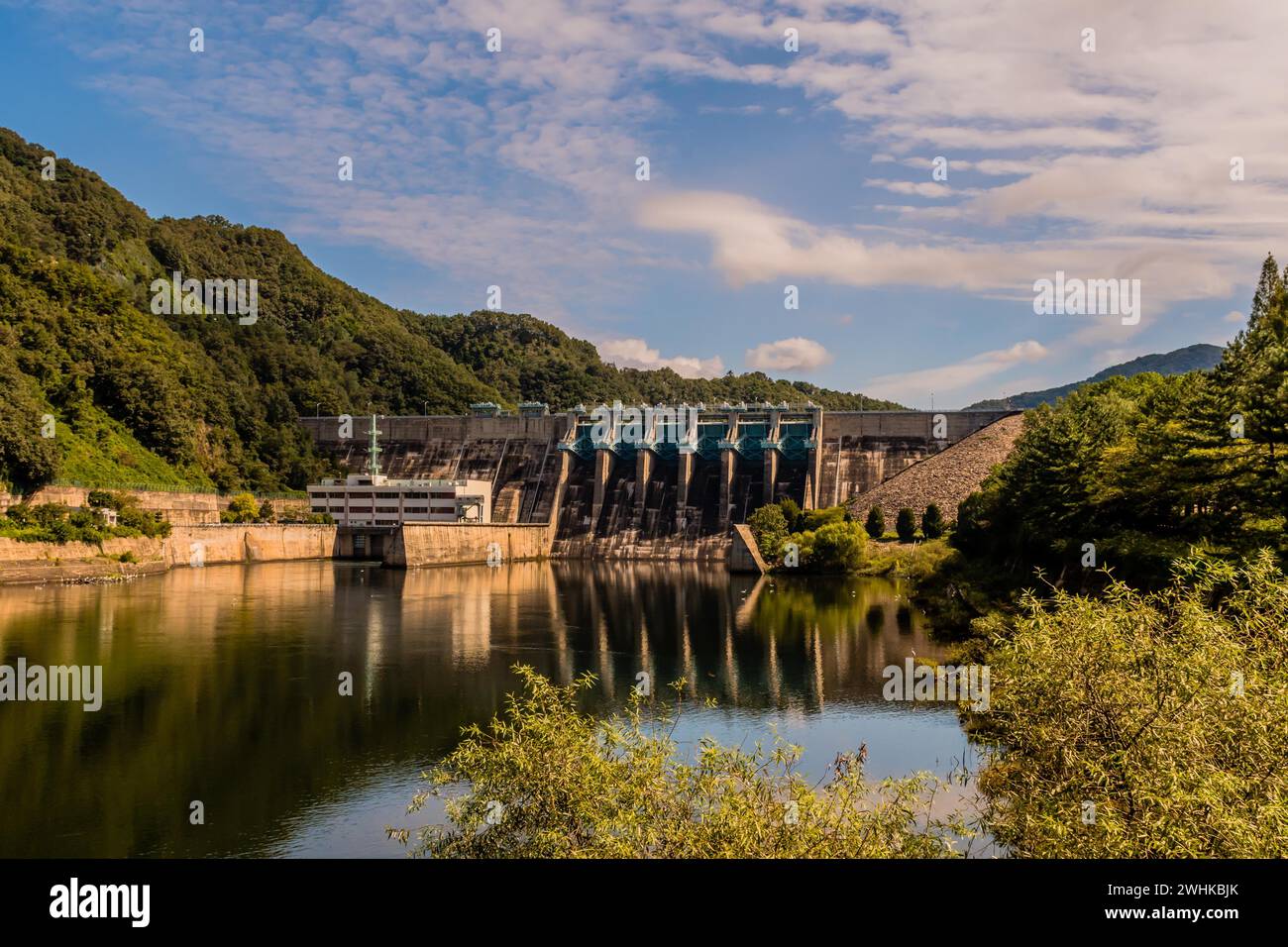 Beautiful landscape of dam on river under cloudy blue sky in mountain ...