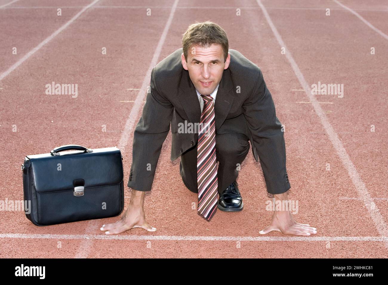 Businessman at the starting line on a running track, symbolic image ...