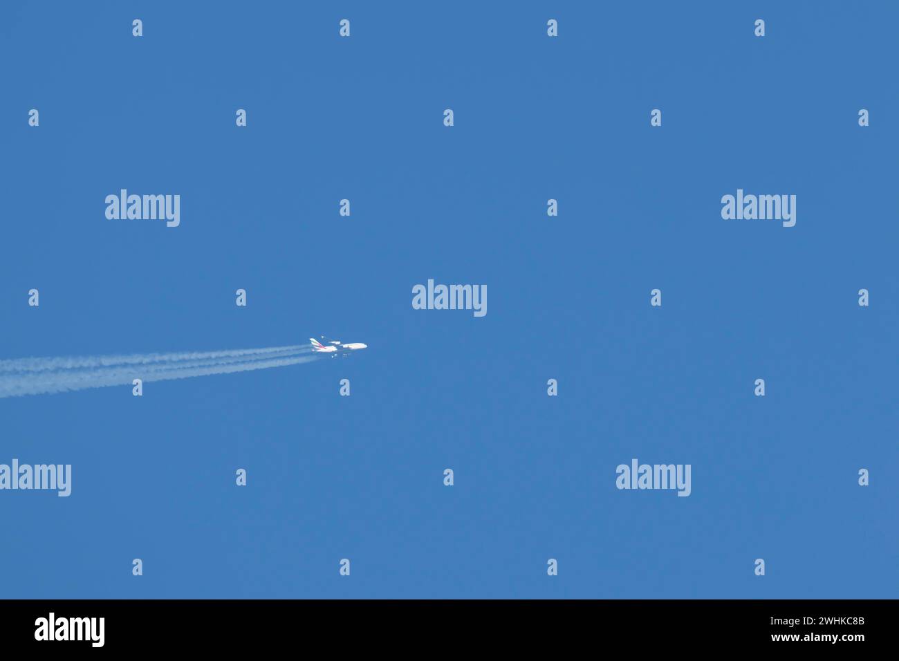 Airbus A380 aircraft of Emirates airlines flying across a blue sky ...