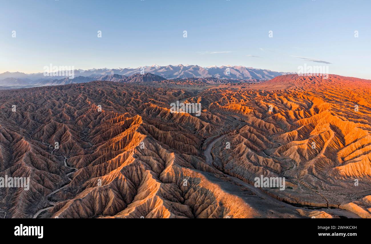 Riverbed in a landscape of eroded hills, badlands at sunrise, Issyk Kul ...