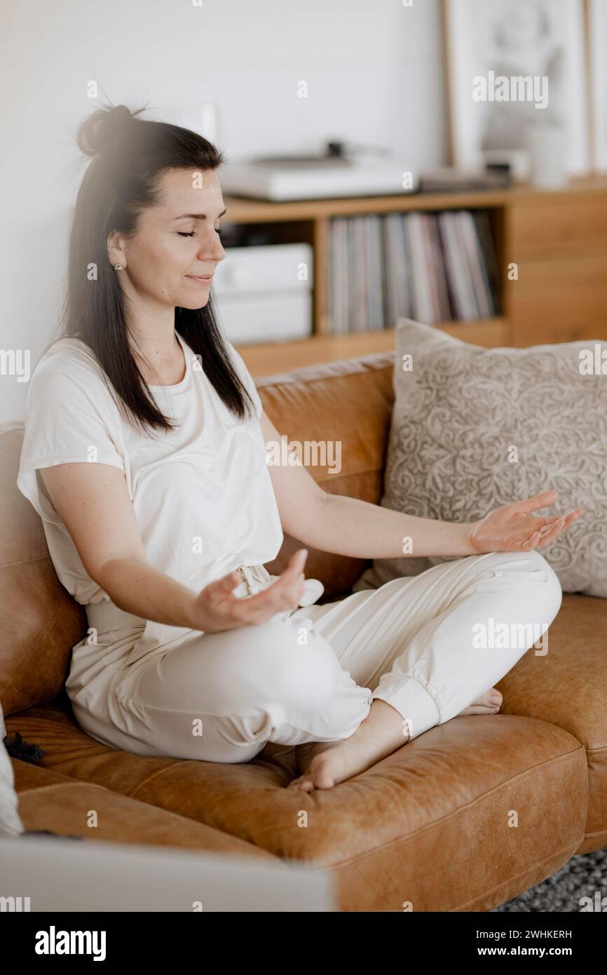 Woman, 40, doing relaxation exercises on a couch Stock Photo - Alamy