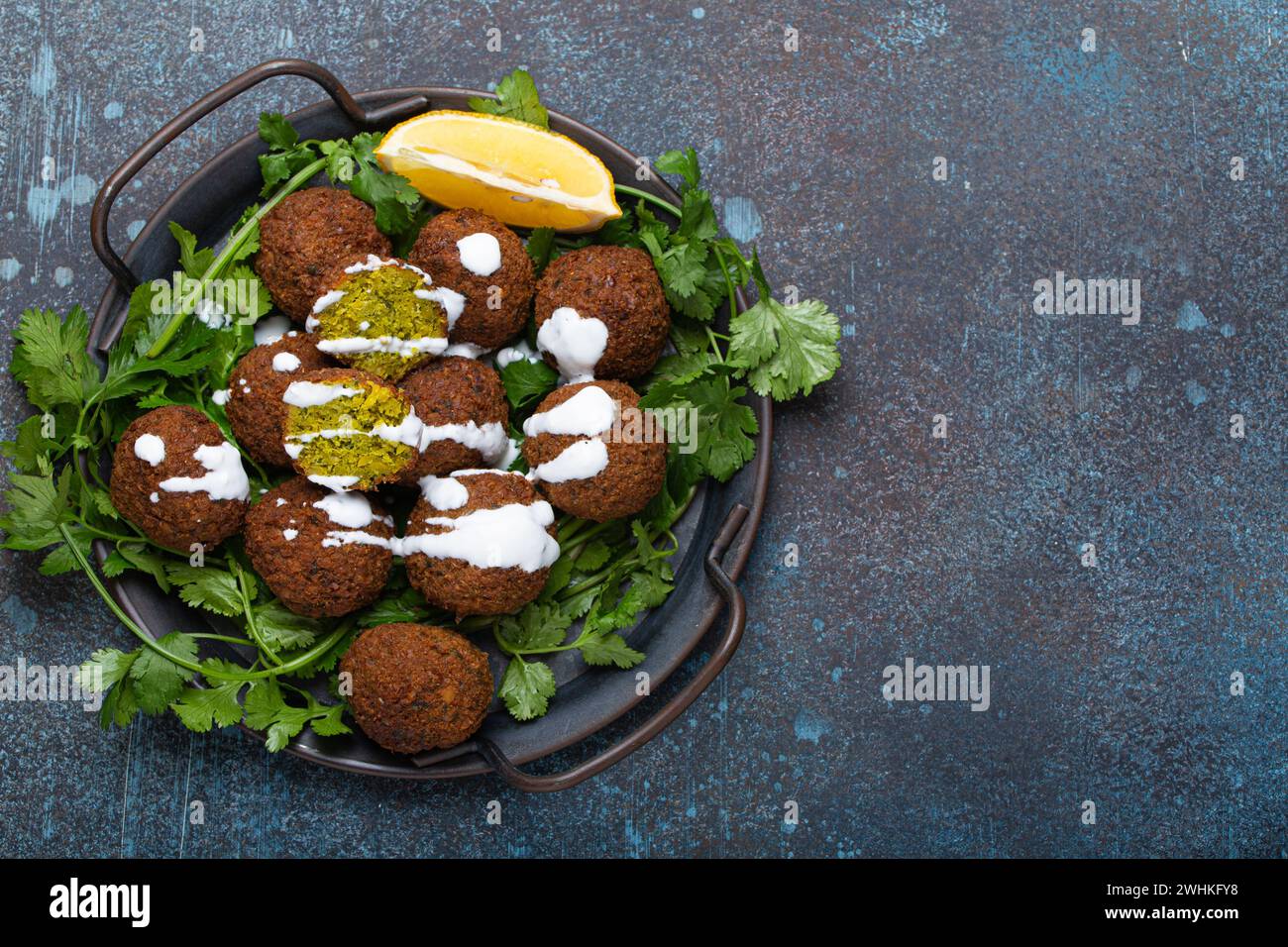 Plate of fried falafel balls served with fresh green cilantro and lemon ...