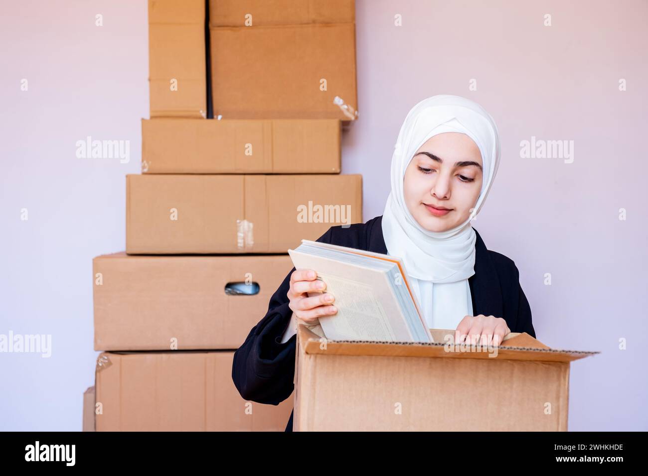 Arabic woman unpacking the boxes after moving Stock Photo - Alamy
