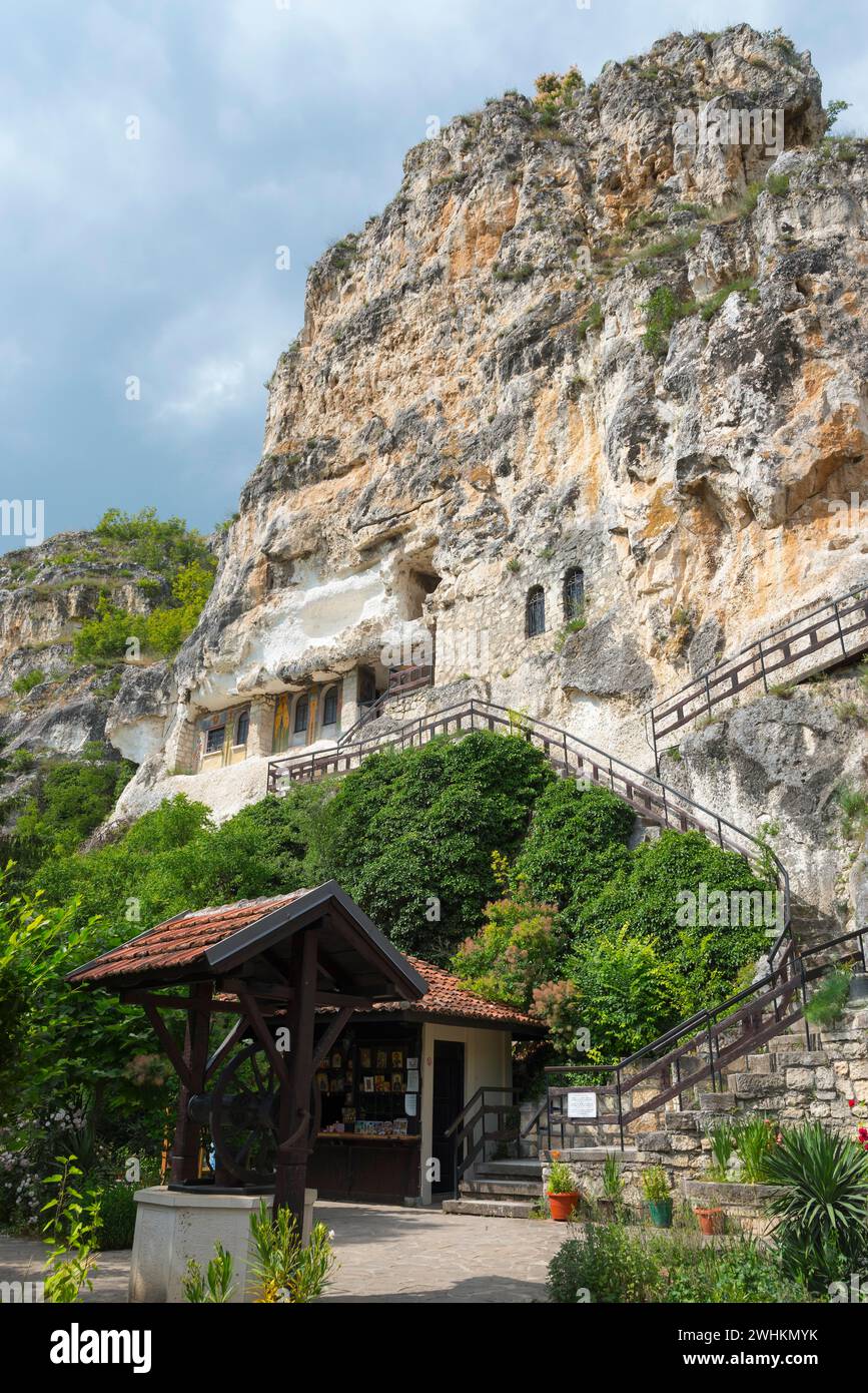 Steep rocky cliff with embedded cave structure and wooden staircase ...