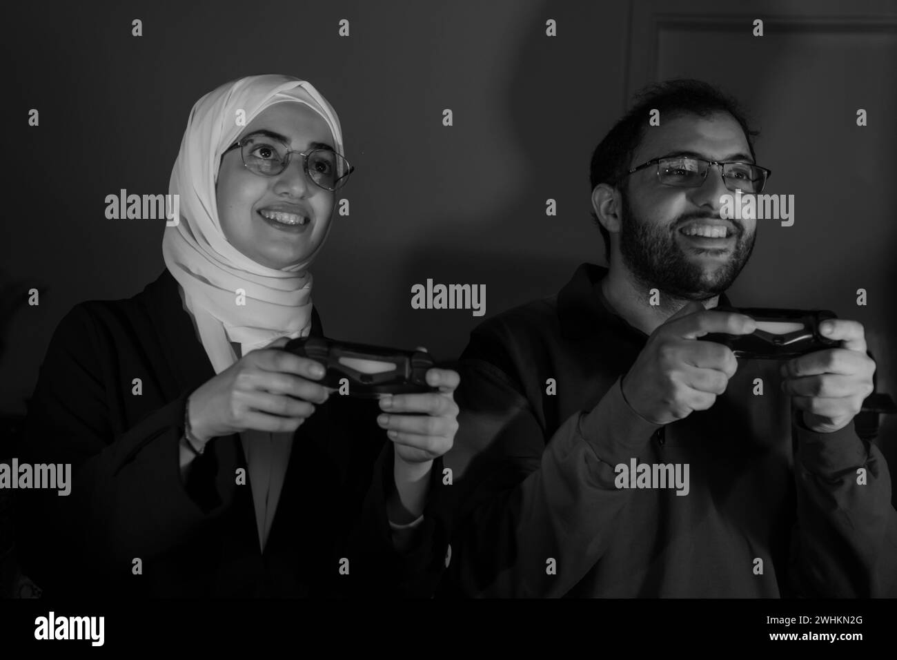 arabic muslim sibling playing together console games Stock Photo - Alamy