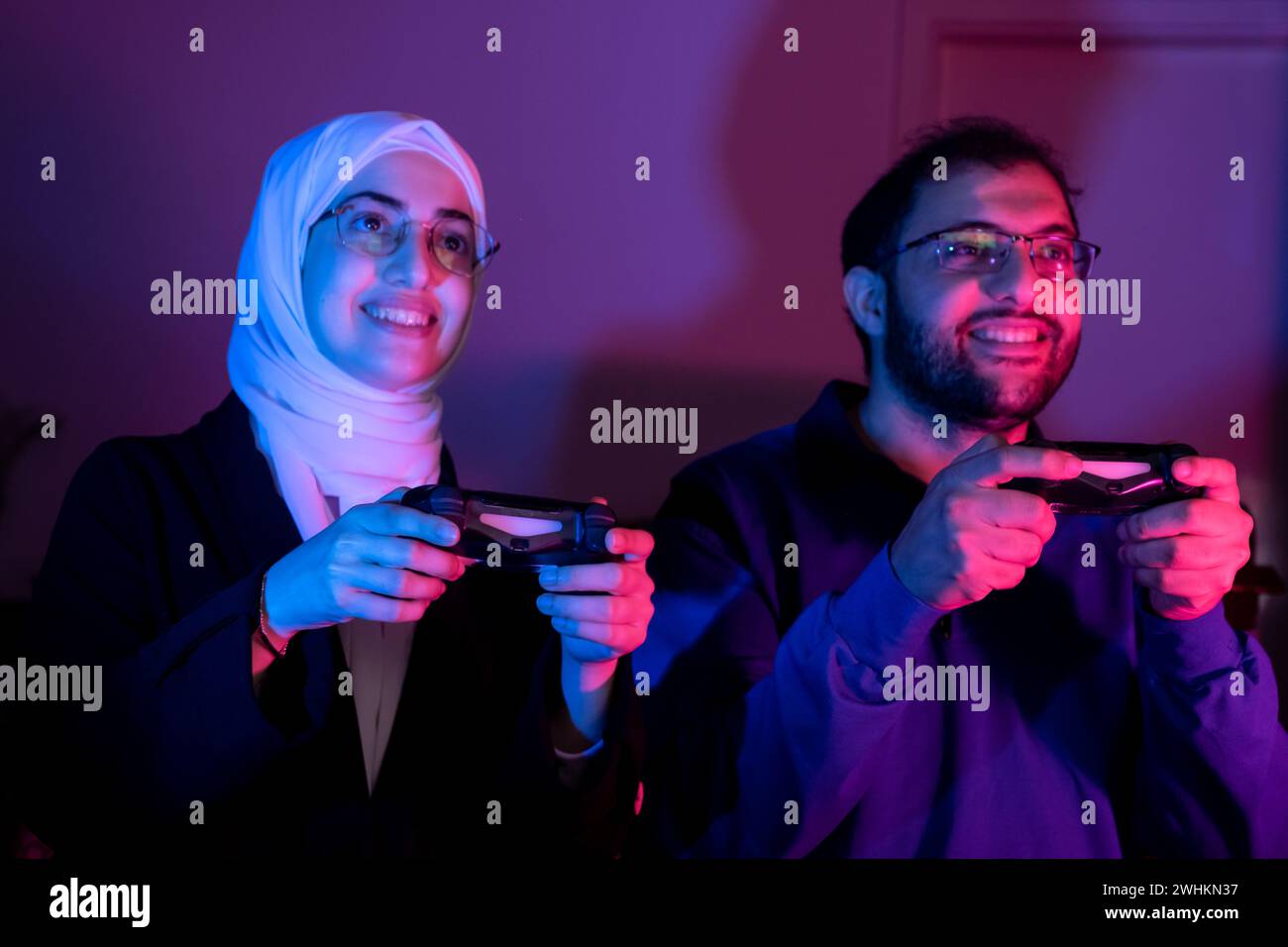 arabic muslim sibling playing together console games Stock Photo - Alamy