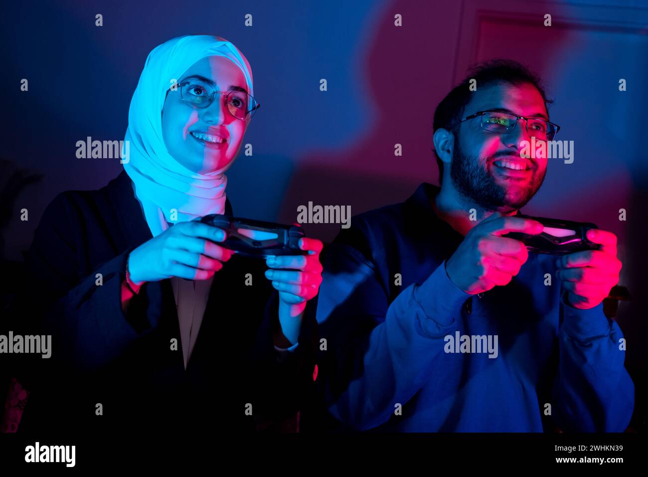 arabic muslim sibling playing together console games Stock Photo - Alamy