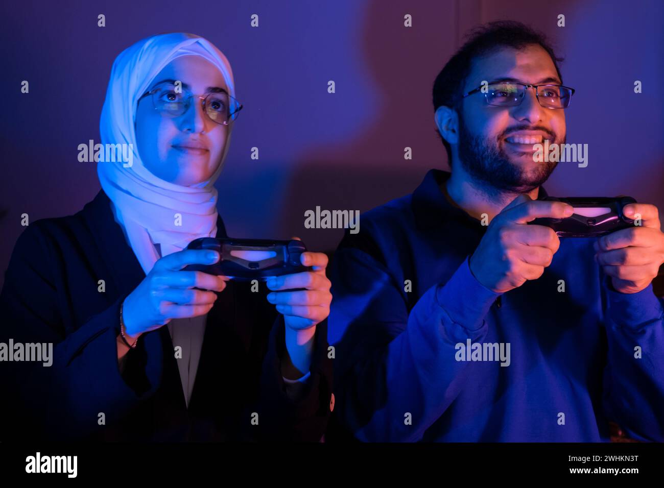 arabic muslim sibling playing together console games Stock Photo - Alamy