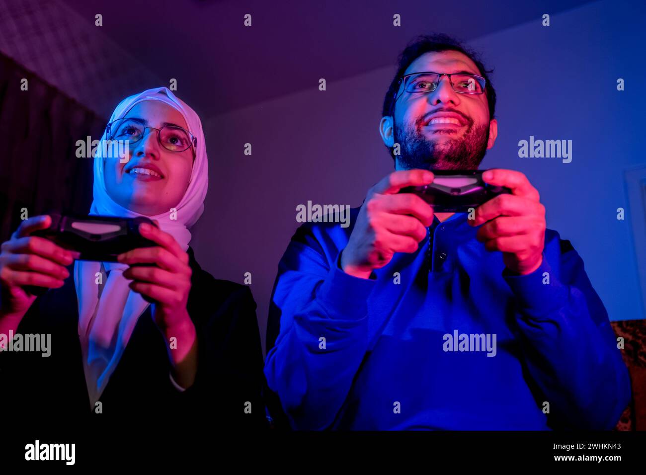 arabic muslim sibling playing together console games Stock Photo - Alamy