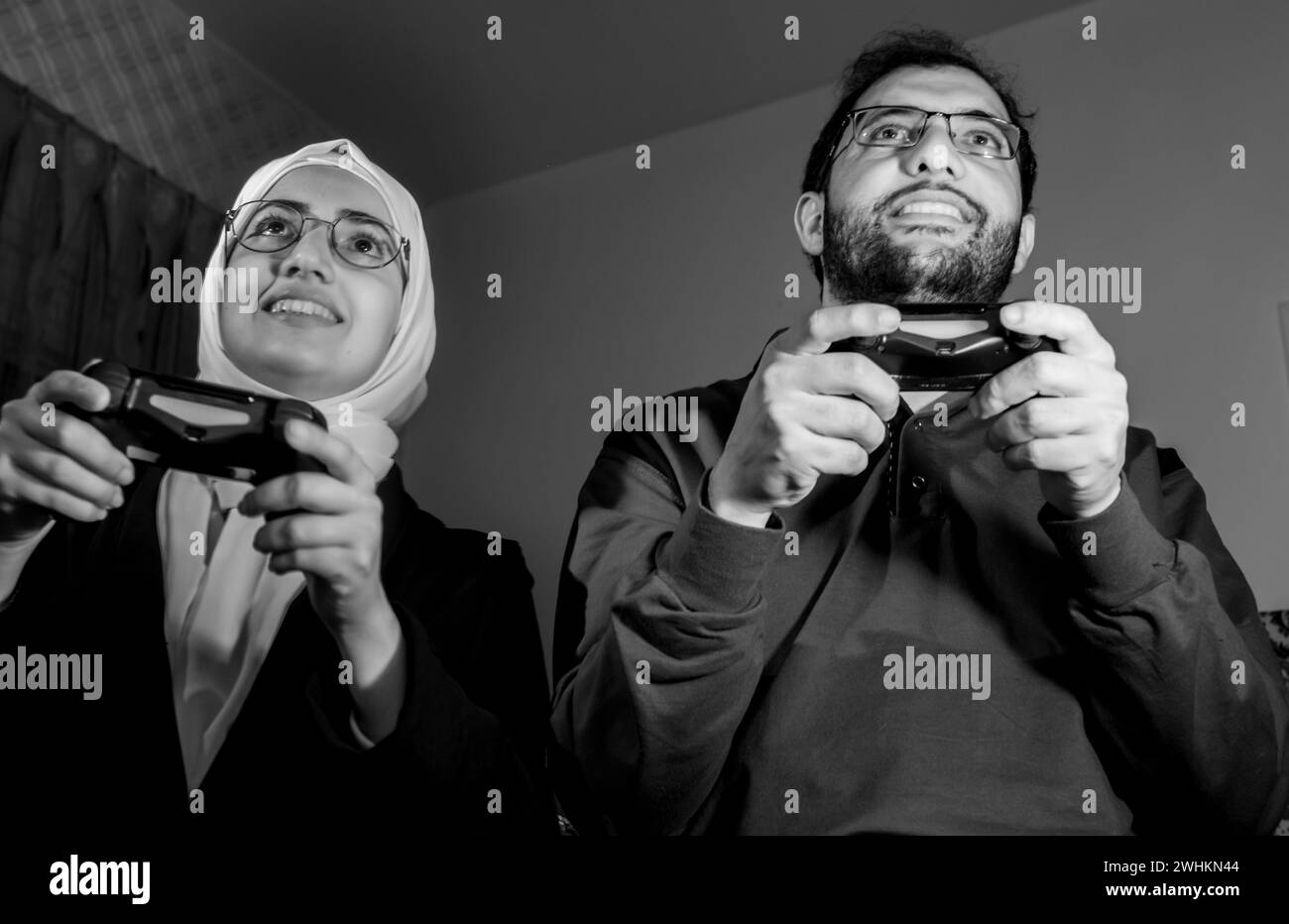 arabic muslim sibling playing together console games Stock Photo - Alamy