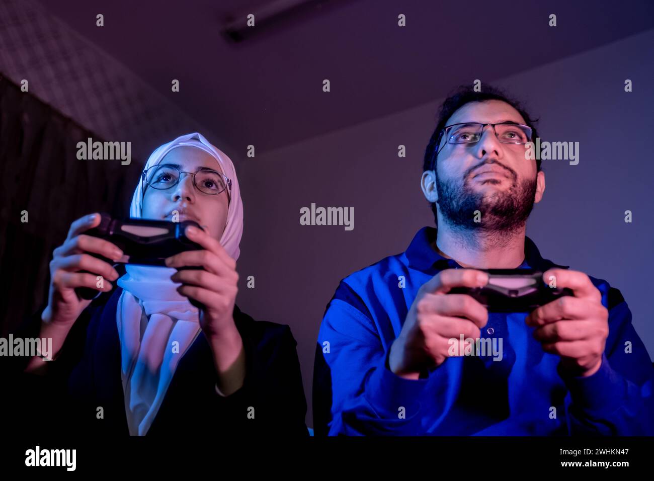 arabic muslim sibling playing together console games Stock Photo - Alamy