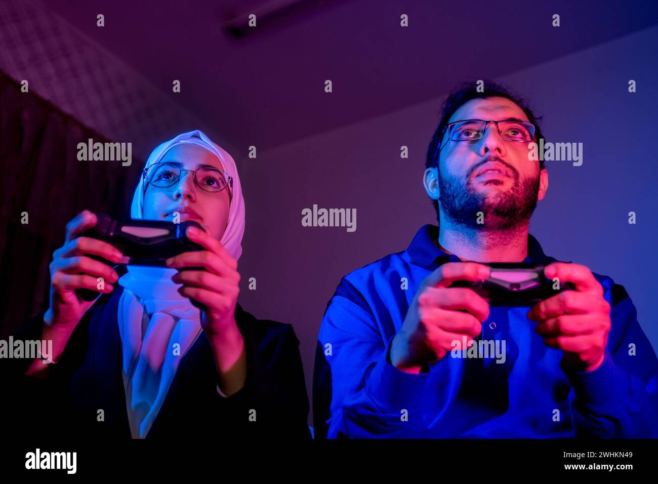 arabic muslim sibling playing together console games Stock Photo - Alamy