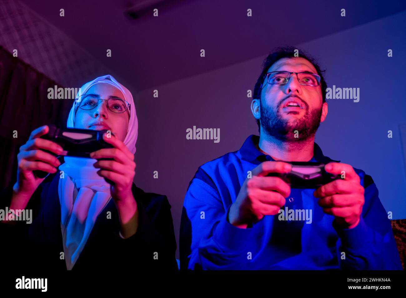 arabic muslim sibling playing together console games Stock Photo - Alamy