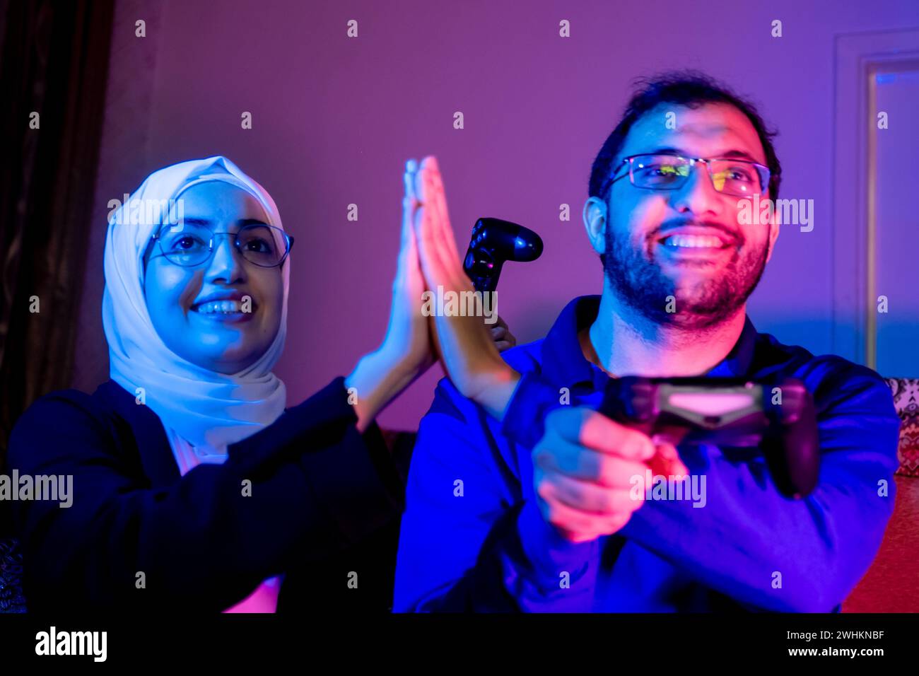 arabic muslim sibling playing together console games Stock Photo - Alamy
