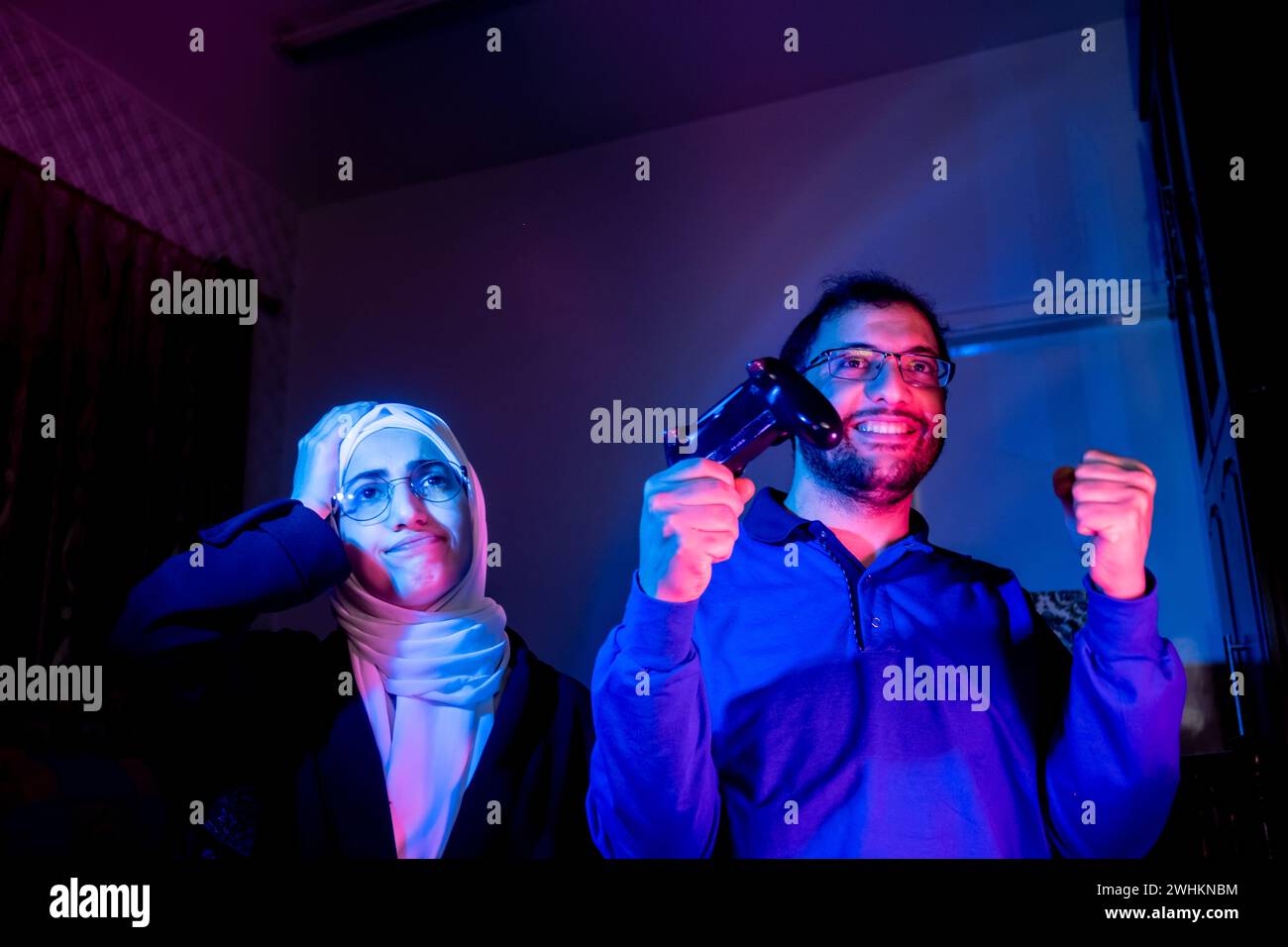 arabic muslim sibling playing together console games Stock Photo - Alamy