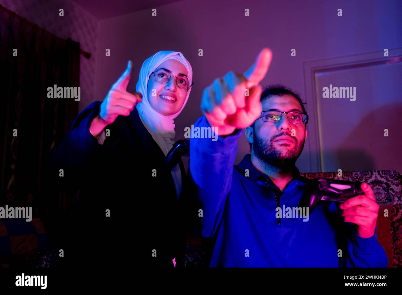 arabic muslim sibling playing together console games Stock Photo - Alamy