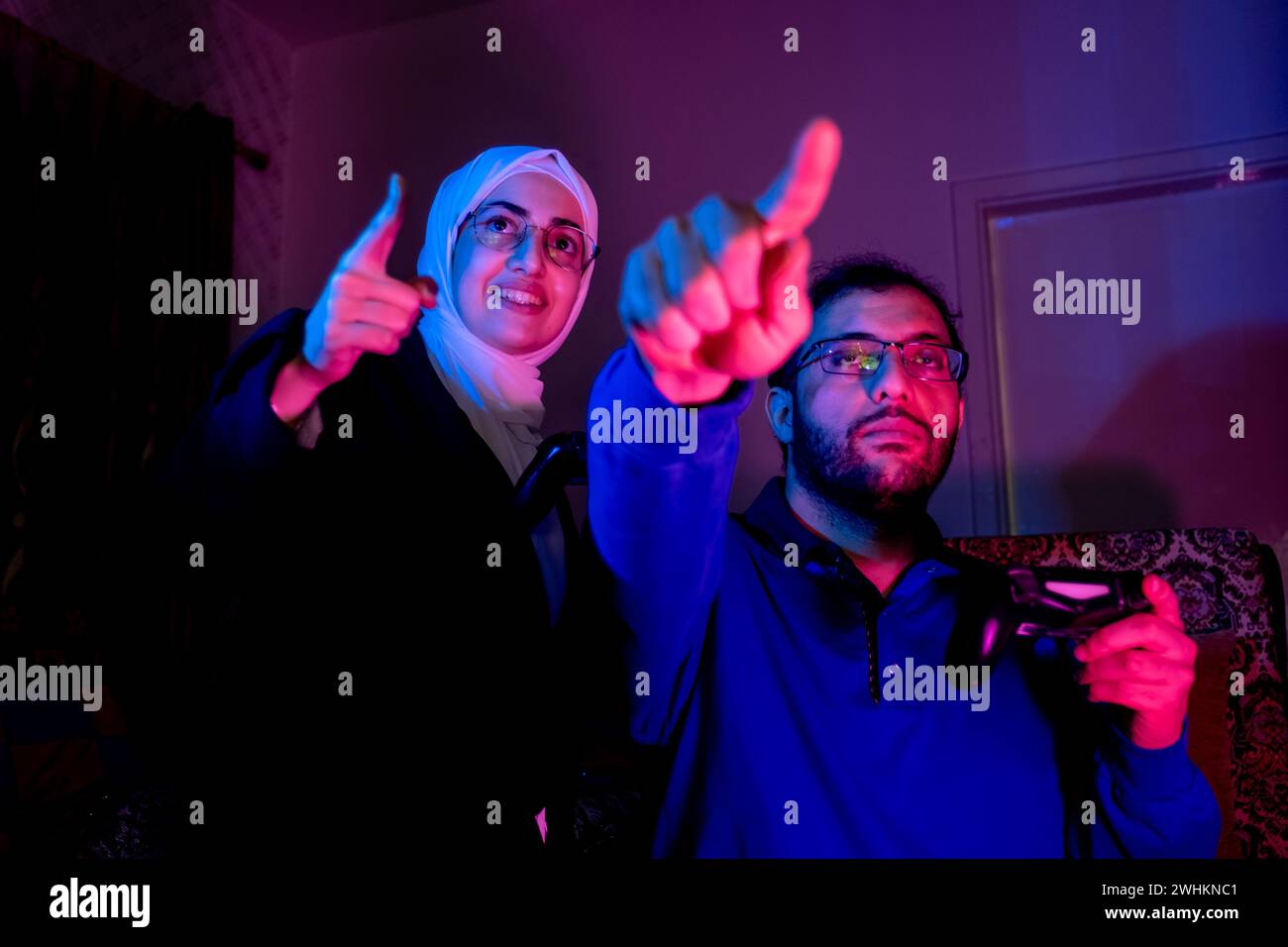 arabic muslim sibling playing together console games Stock Photo - Alamy