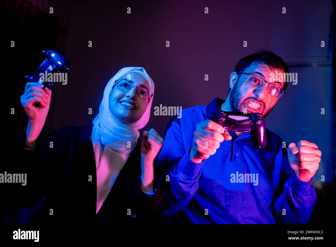 arabic muslim sibling playing together console games Stock Photo - Alamy