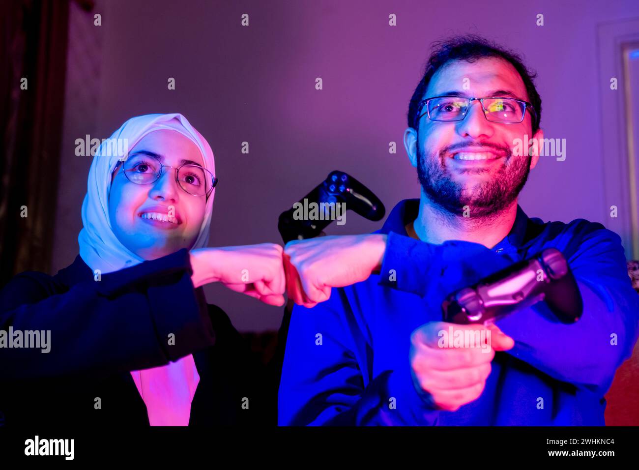 arabic muslim sibling playing together console games Stock Photo - Alamy