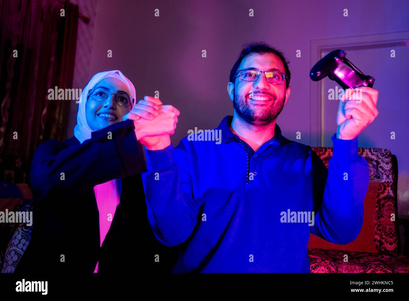 arabic muslim sibling playing together console games Stock Photo - Alamy