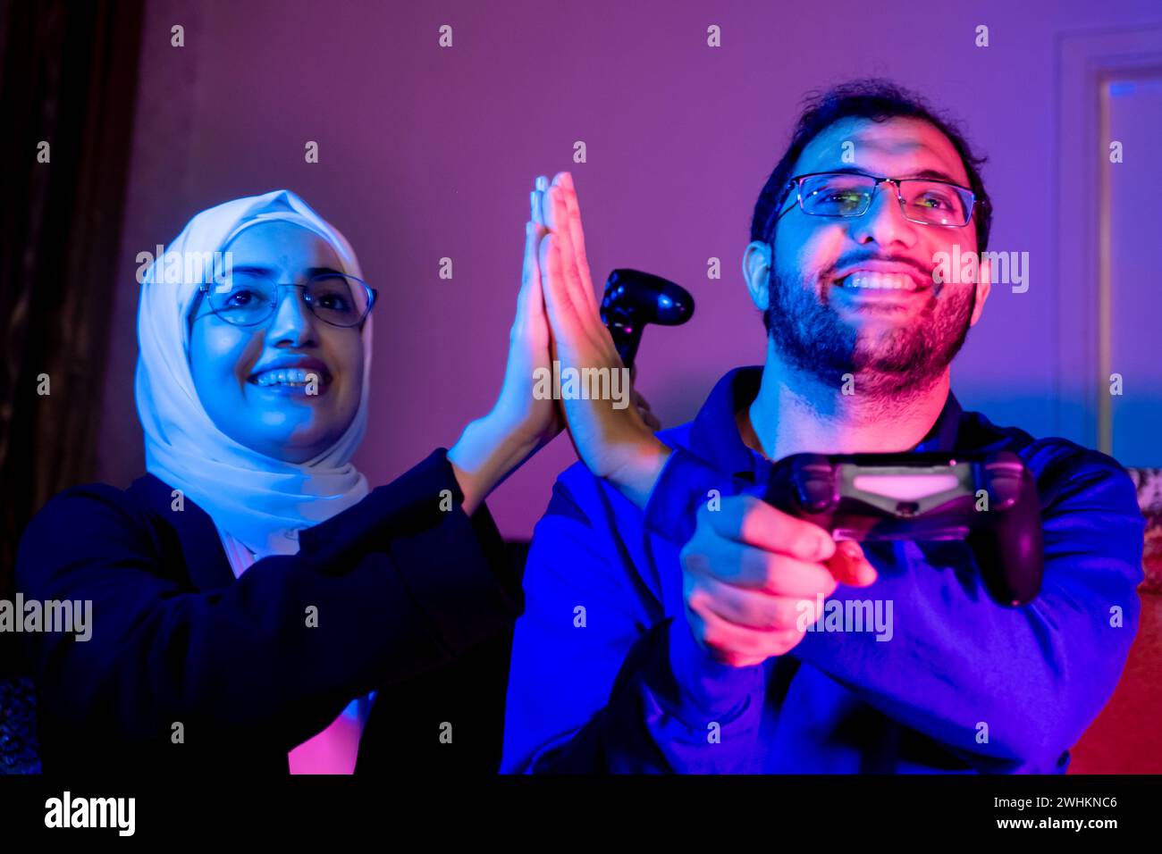 arabic muslim sibling playing together console games Stock Photo - Alamy