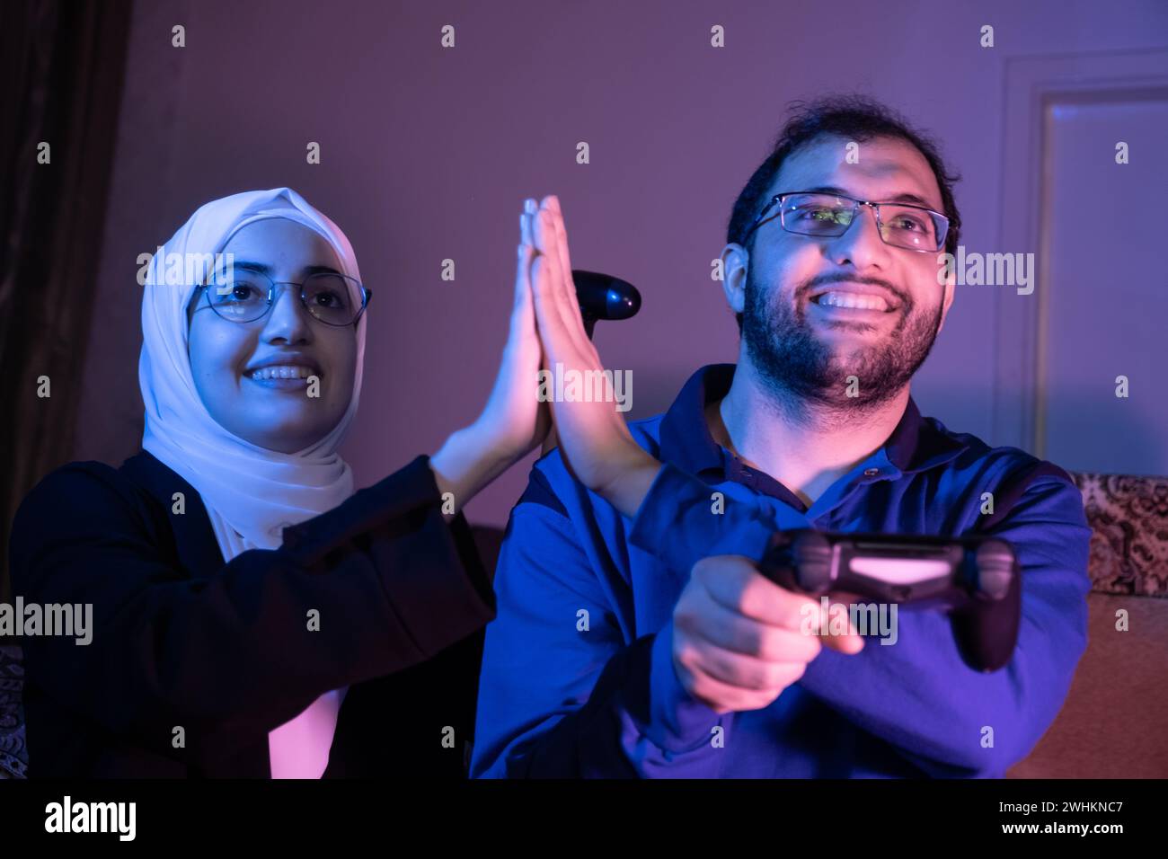 arabic muslim sibling playing together console games Stock Photo - Alamy
