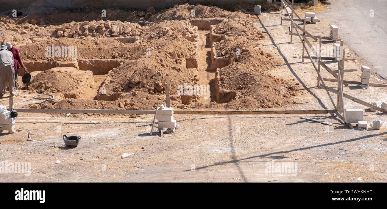 Workers are digging up the foundations for a new house according to the ...