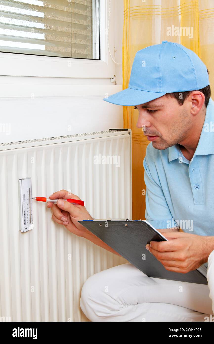 A fitter reads the consumption on the radiator, heating fitter, save ...