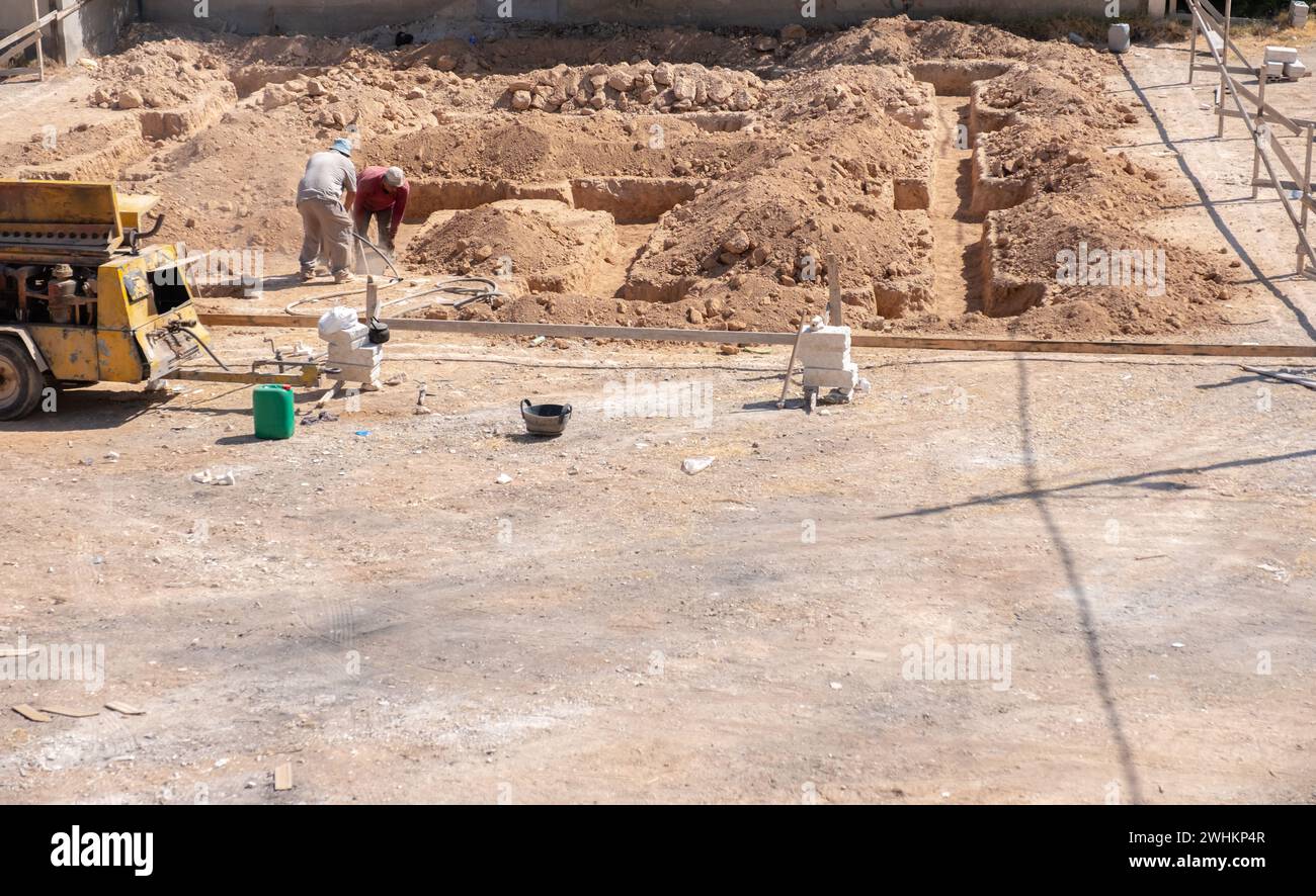 Workers are digging up the foundations for a new house according to the ...