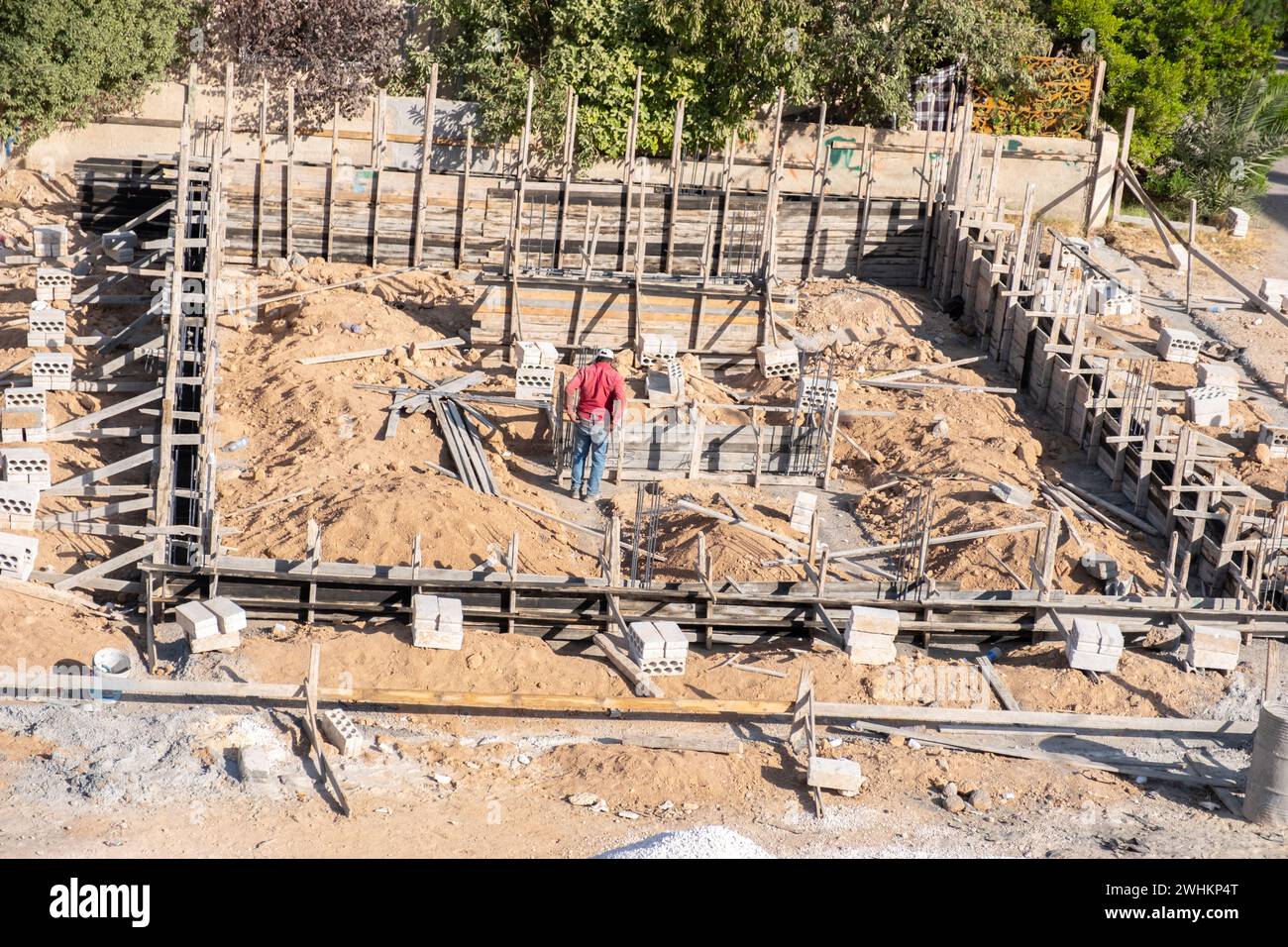 Workers are digging up the foundations for a new house according to the ...