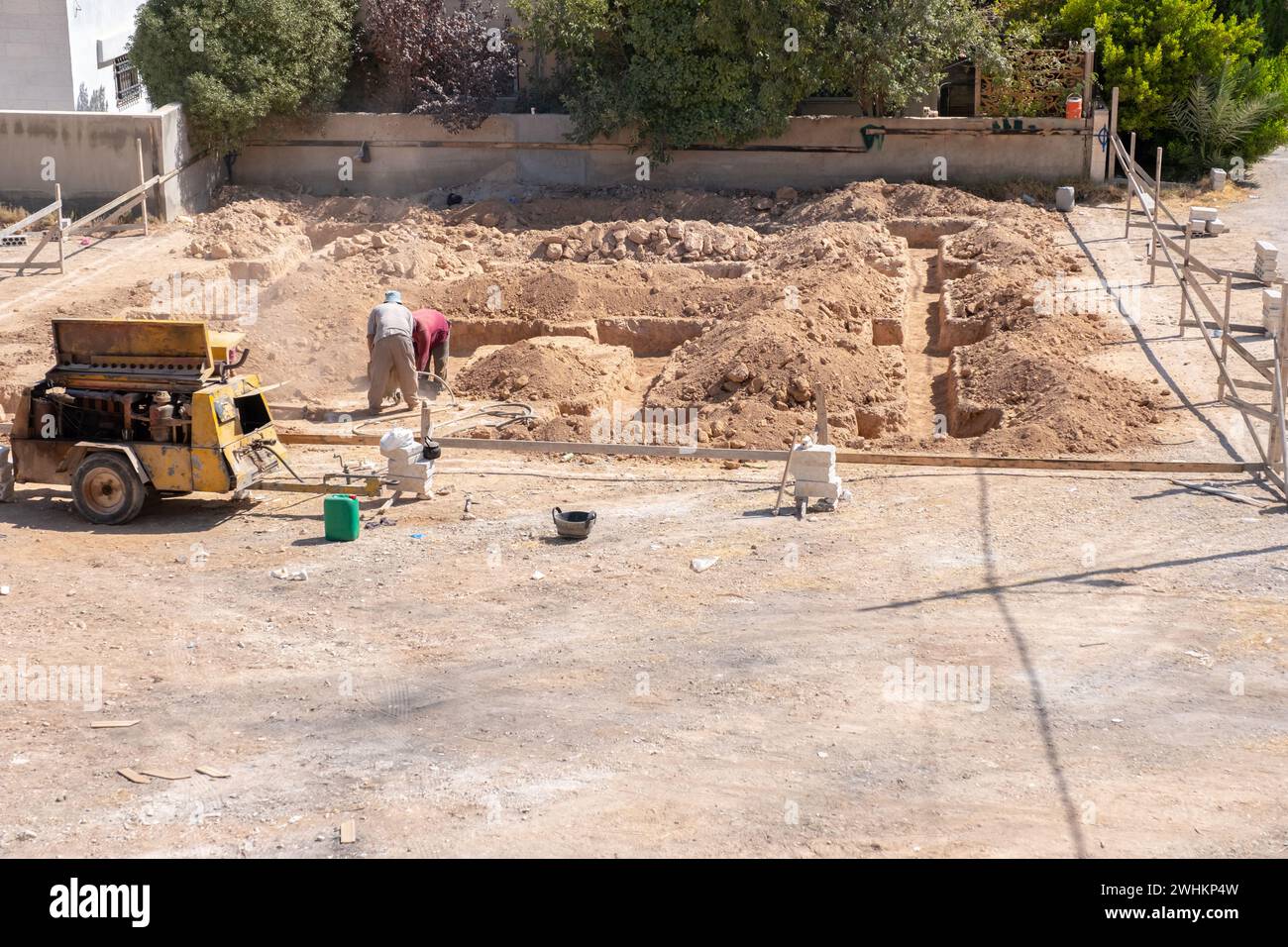 Workers are digging up the foundations for a new house according to the ...
