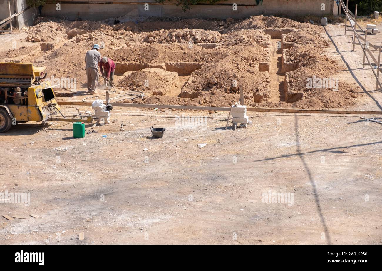 Workers are digging up the foundations for a new house according to the ...