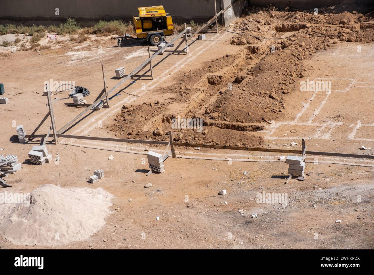 Workers are digging up the foundations for a new house according to the ...