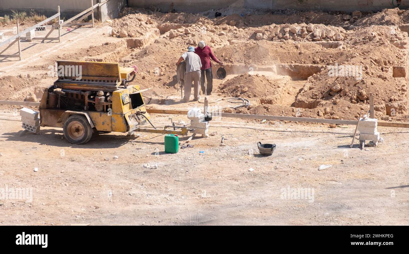Workers are digging up the foundations for a new house according to the ...