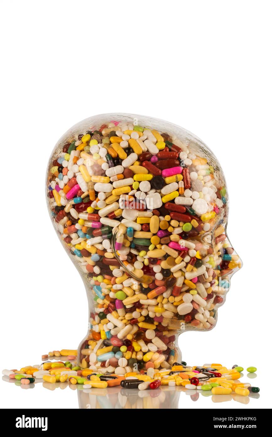 A glass head filled with many tablets. Symbolic photo for medication ...