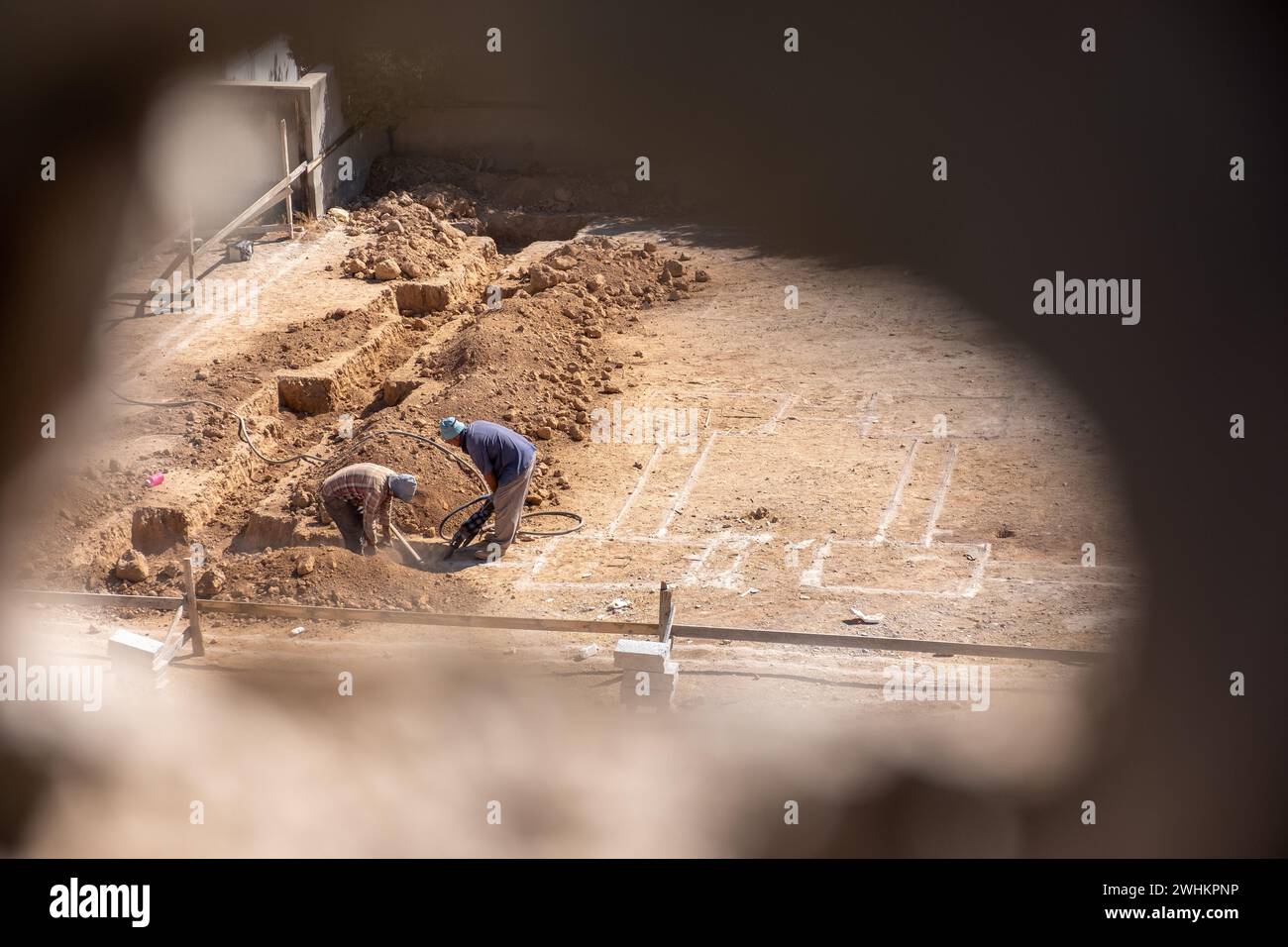 a photo through a hole for a workers are digging up the foundations for ...