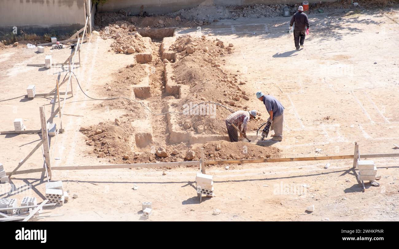 Workers are digging up the foundations for a new house according to the ...