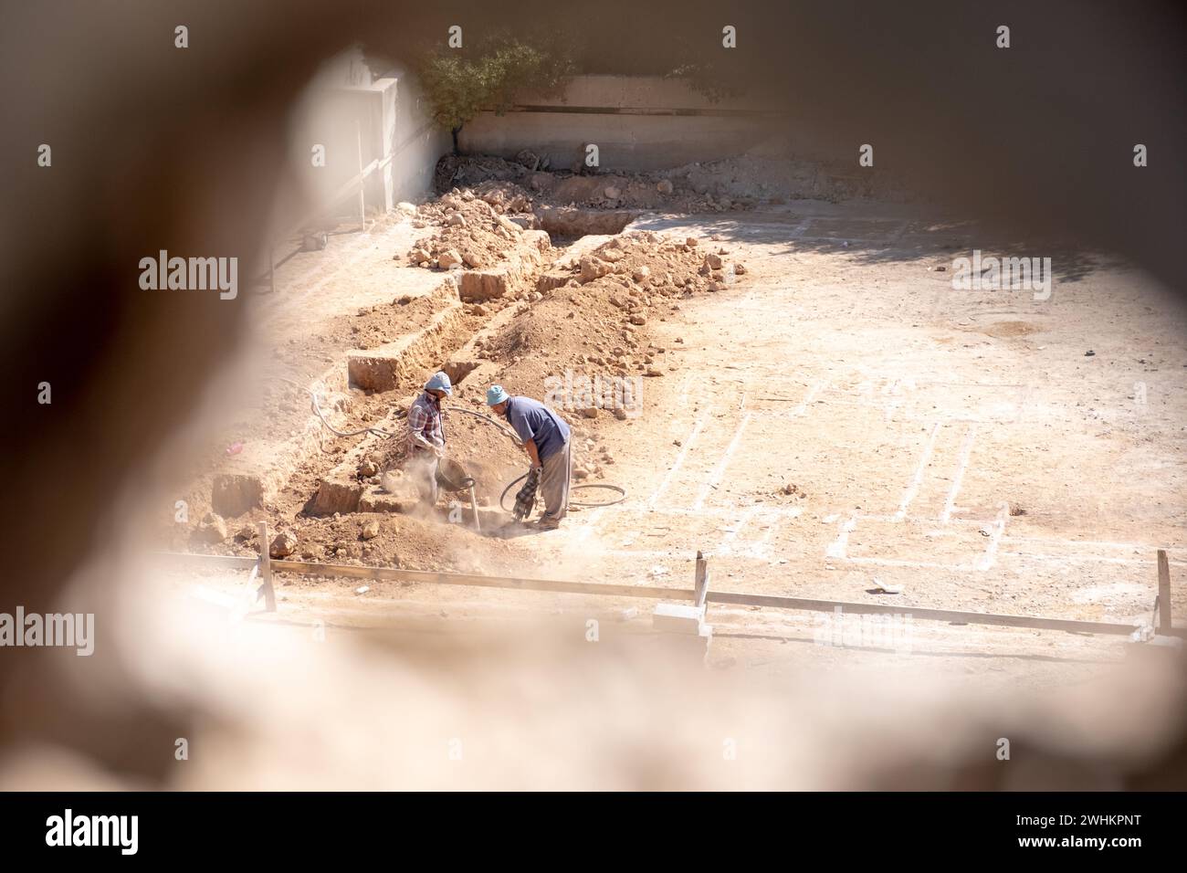 a photo through a hole for a workers are digging up the foundations for ...