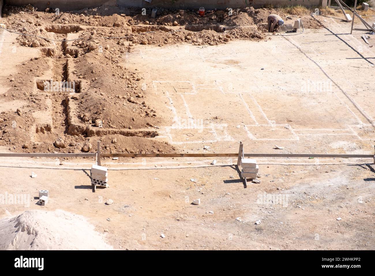 Workers are digging up the foundations for a new house according to the ...