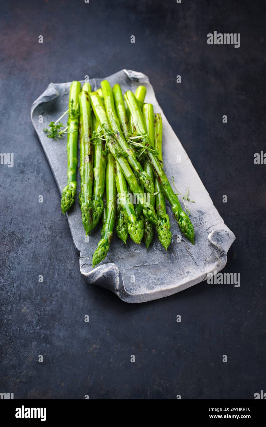 Green asparagus glazed with cress as garnish served as close-up on a ...