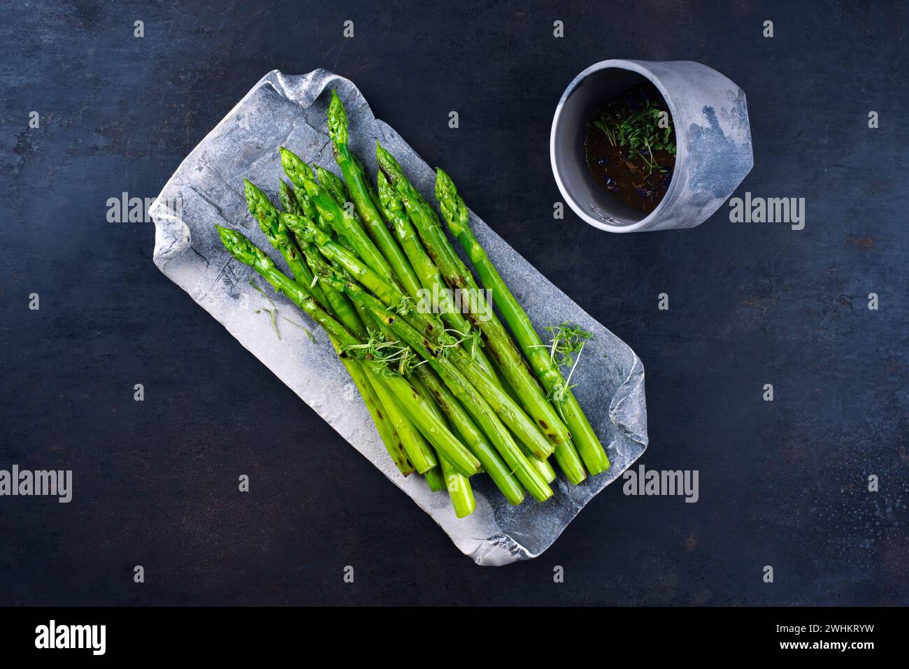 Green asparagus glazed with cress as garnish served as top view on a ...