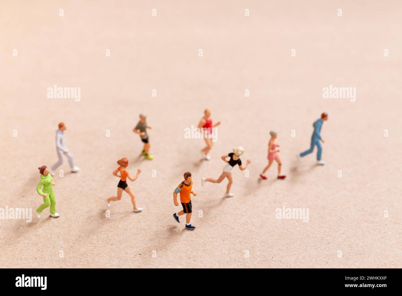 Miniature People exercising while running in a group on the beach Stock ...