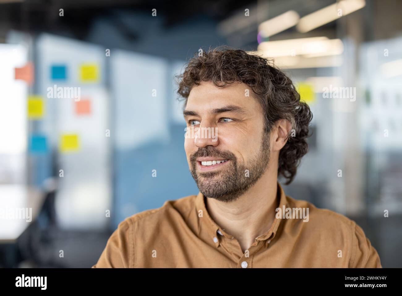 Joyful successful businessman close-up pensive and dreamy looking out ...