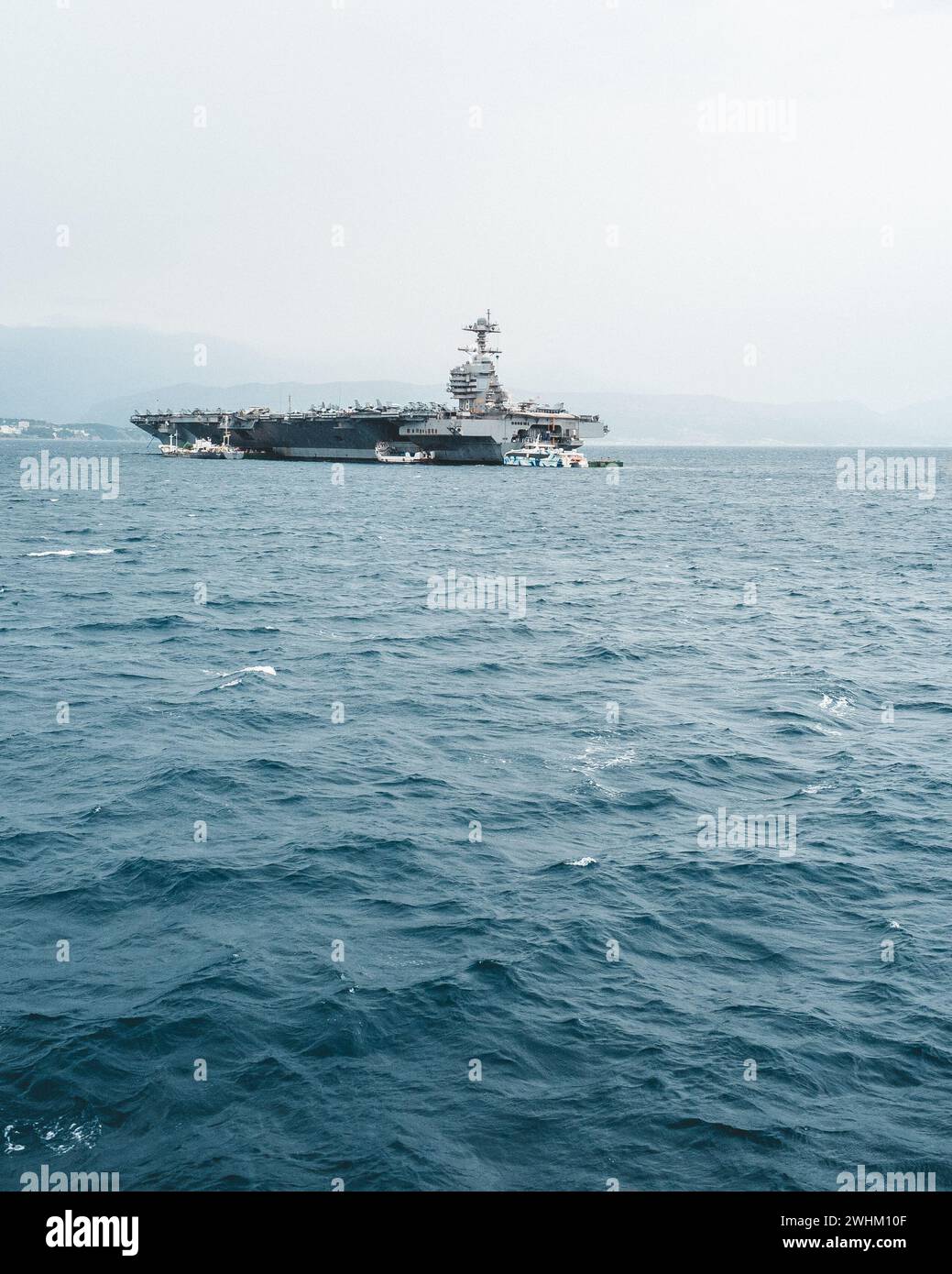 A massive vessel sails alongside another ship in the vast oceank Stock ...