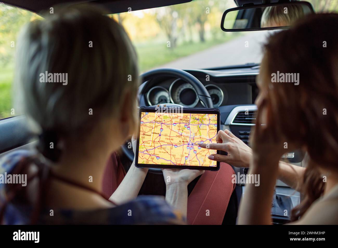 Happy young two women driver tourist travelers with digital tablet USA ...